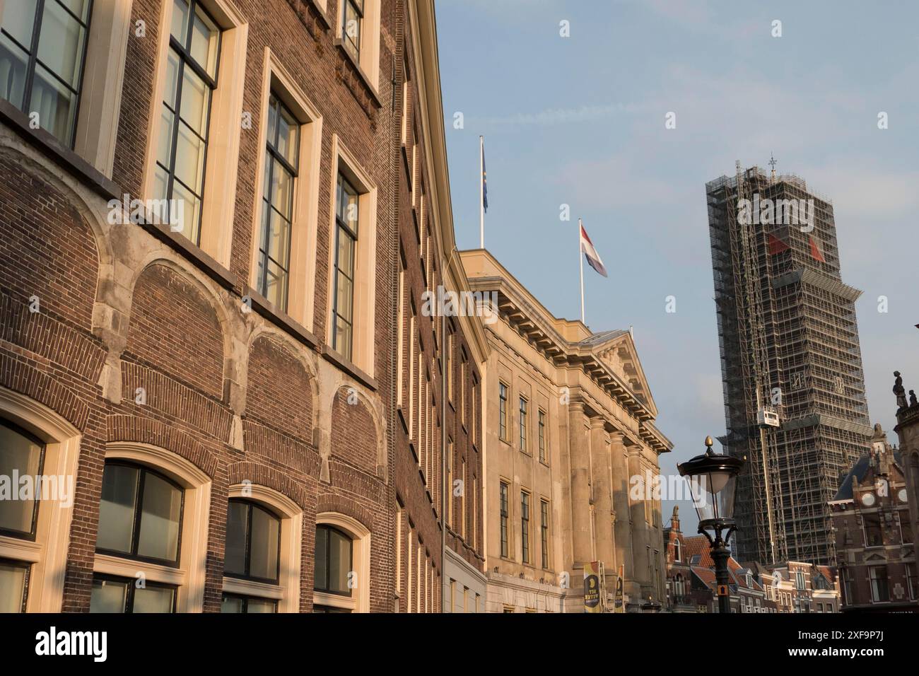 Historic buildings and brick houses in evening light with a flag on a ...