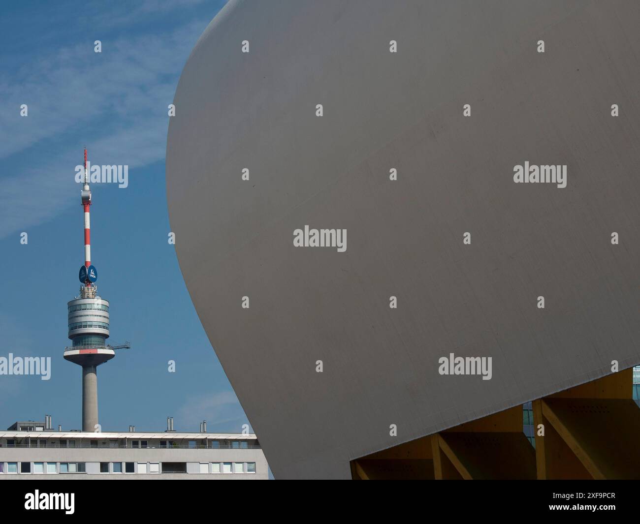 Modern television tower with surrounding buildings under a clear sky ...