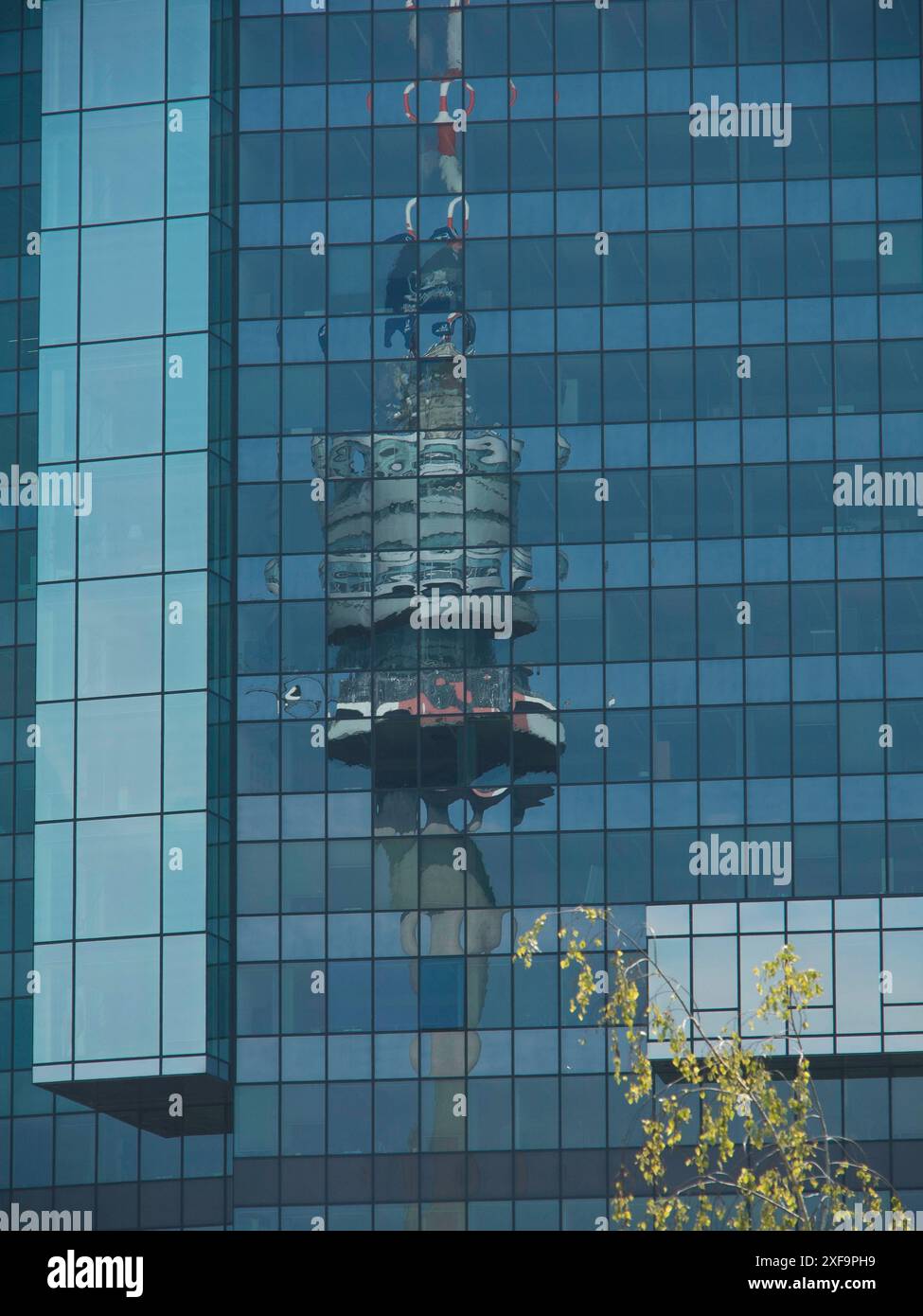Reflection of a tower block on the glass facade of a modern building ...