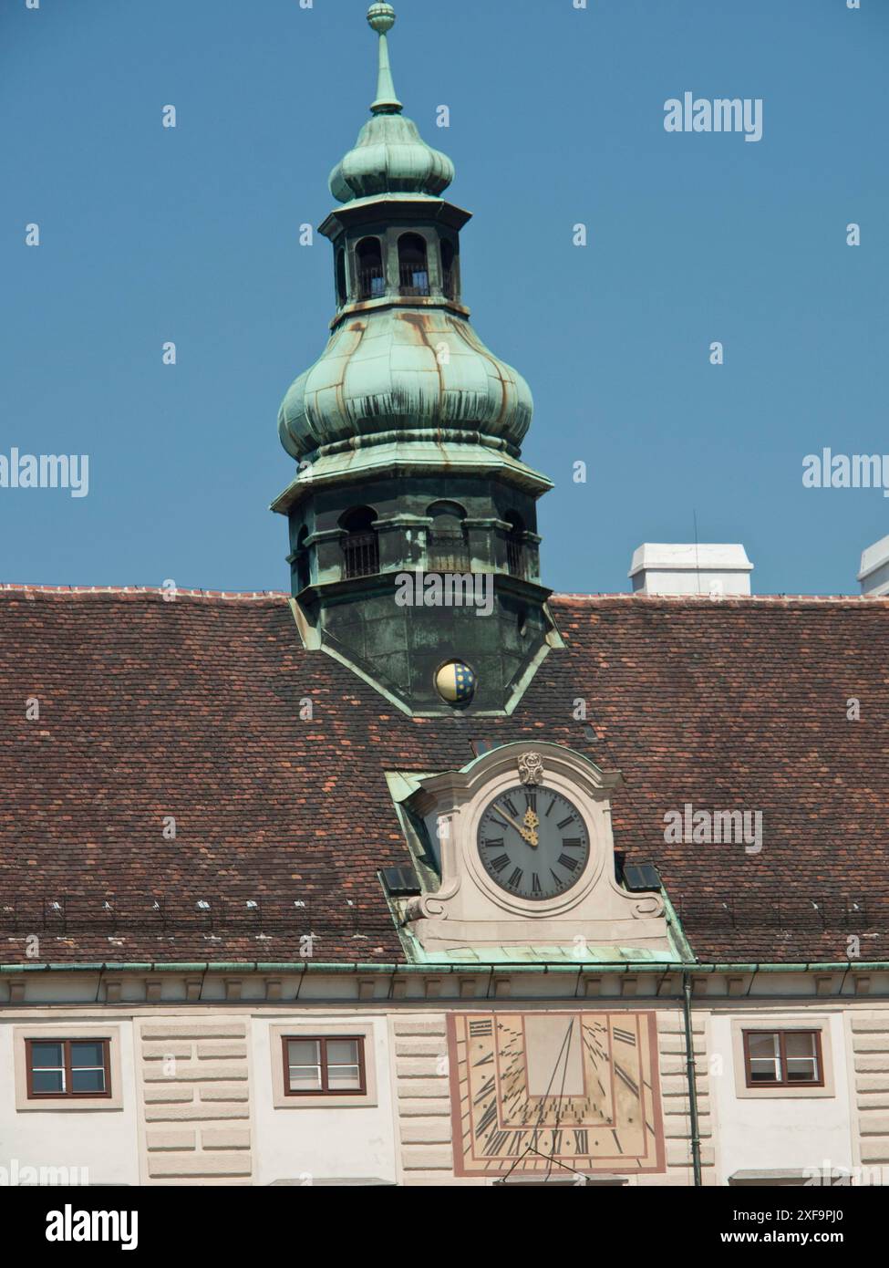 Detailed view of a historic clock tower with sundial and green spire on ...