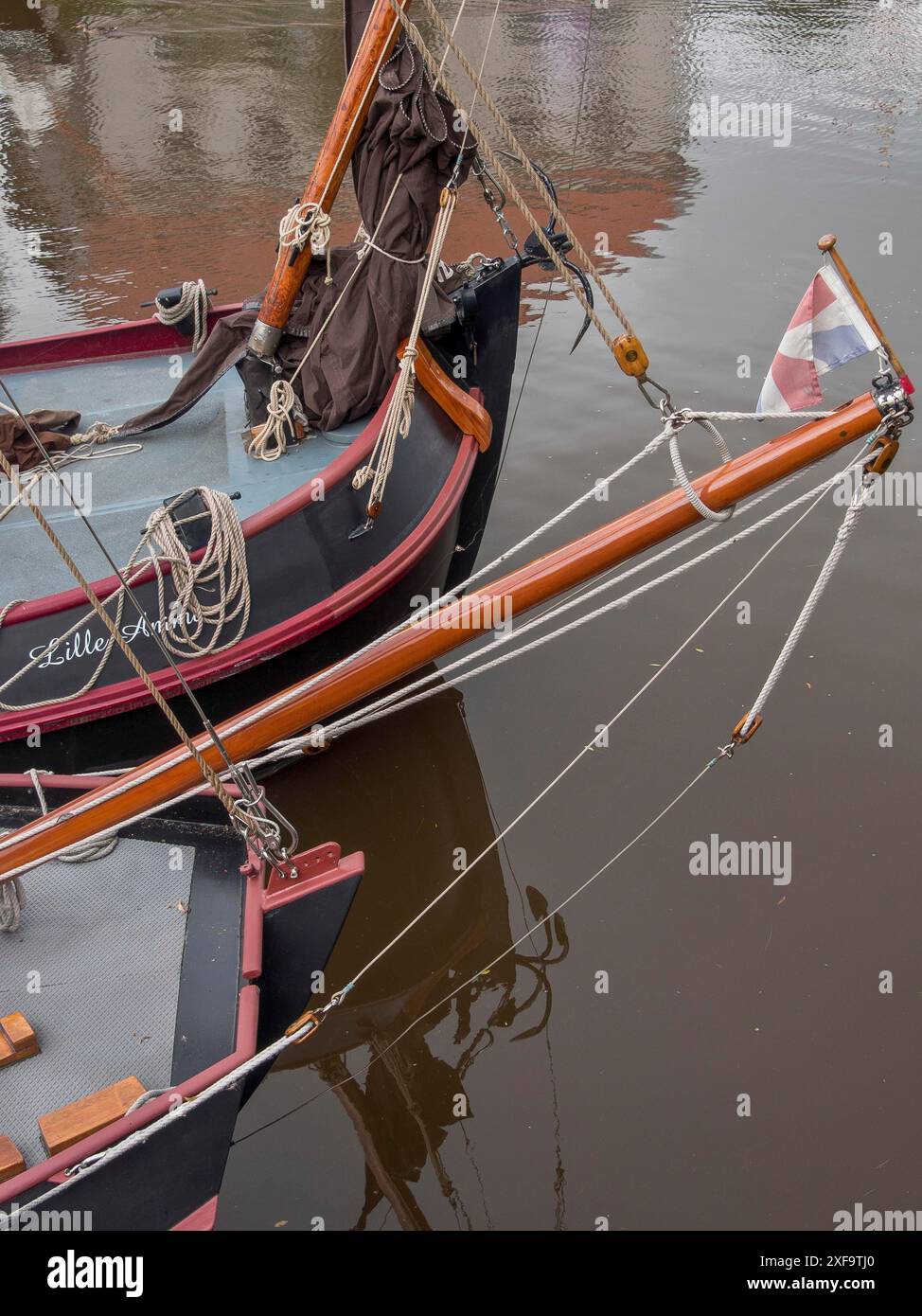 Two sailing boats moored in the water, their colourful hull and wood ...