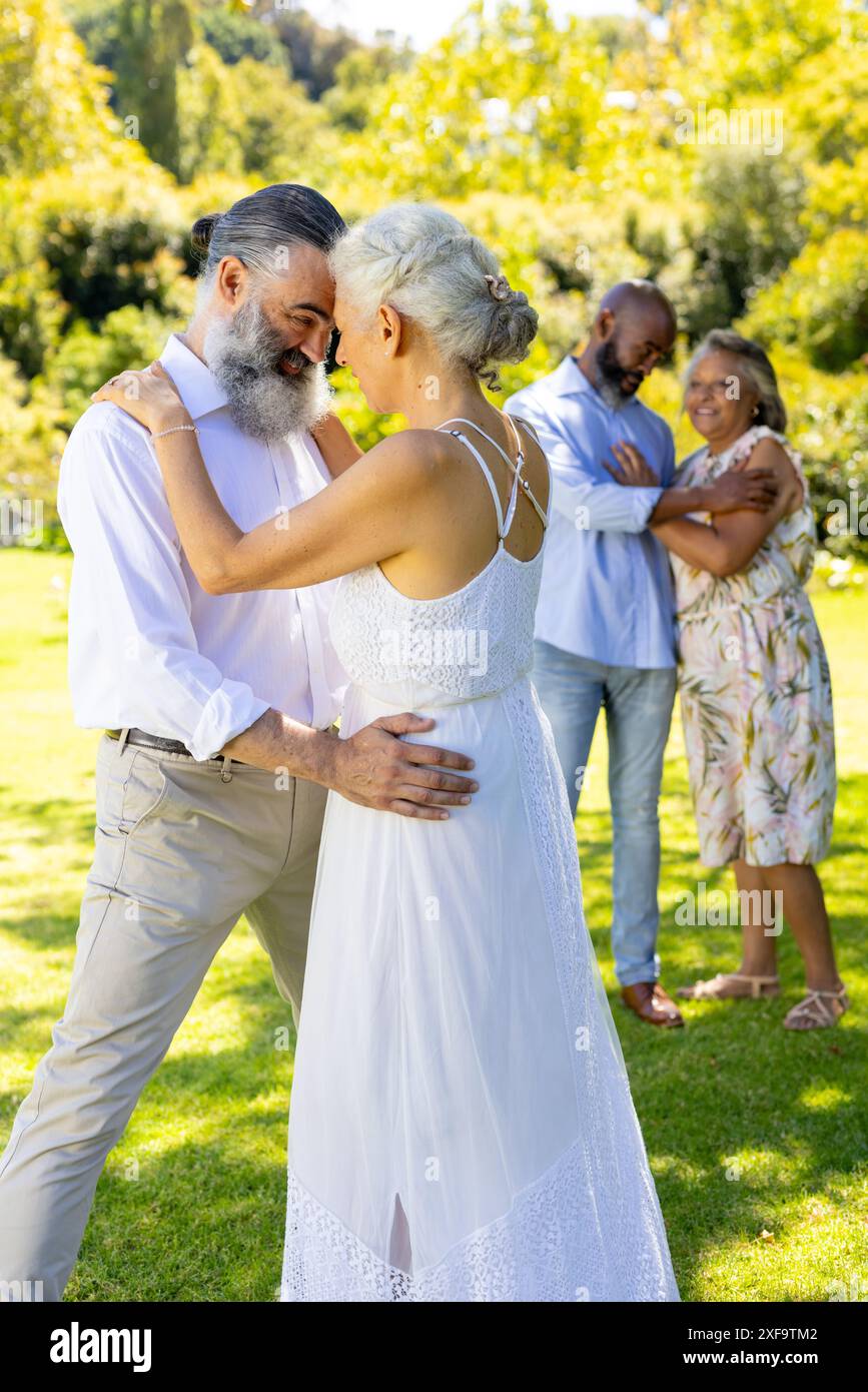 Senior bride and groom dancing together in park, enjoying outdoor ...