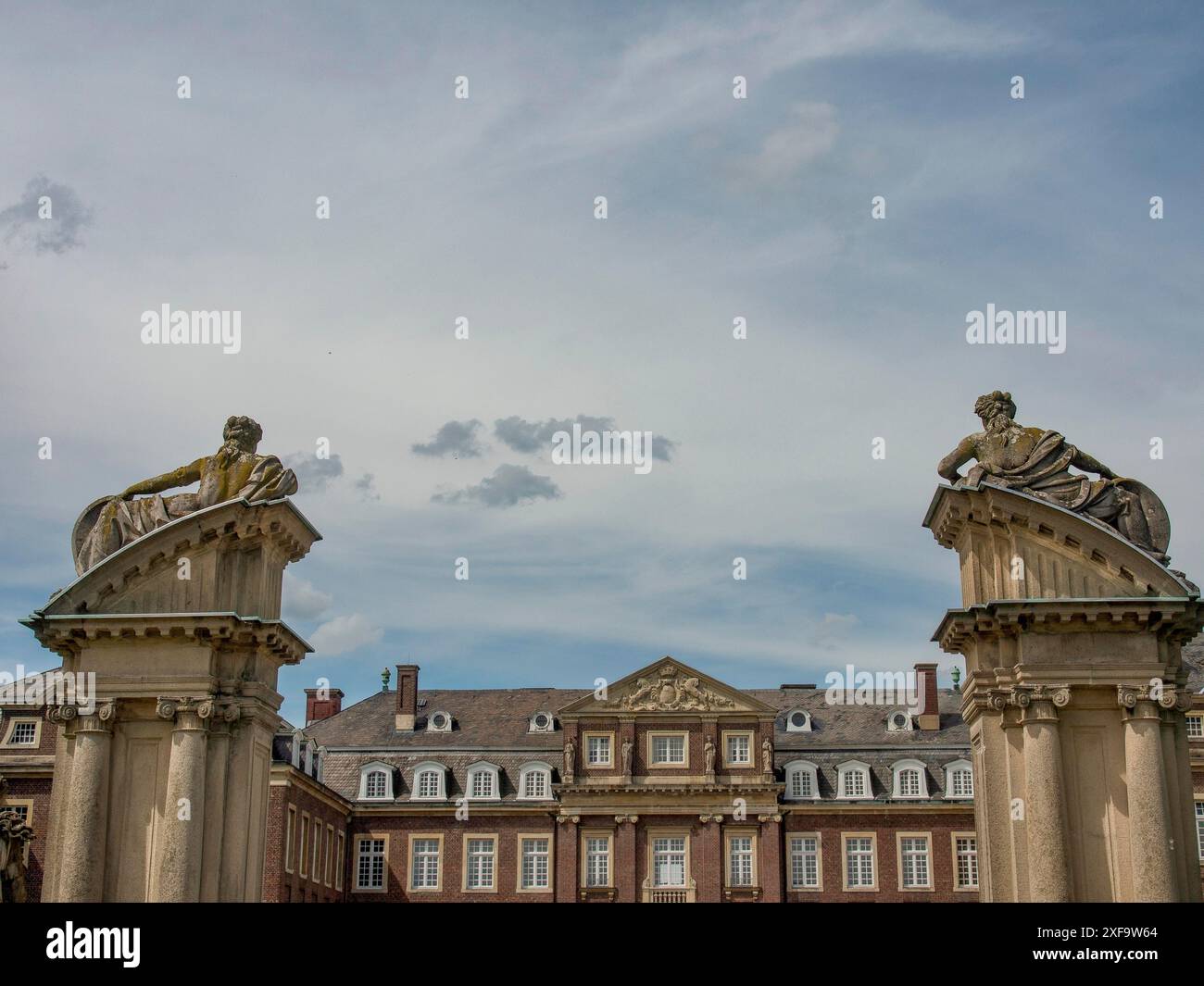 Two decorated columns with sculptures in front of a historic castle ...