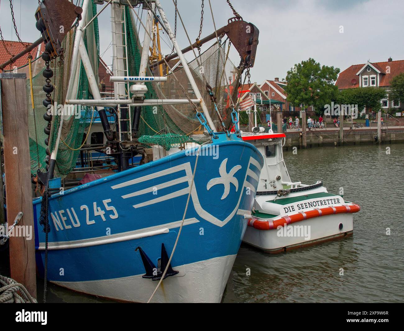 Harbour view with a blue fishing boat and a lifeboat, traditional ...