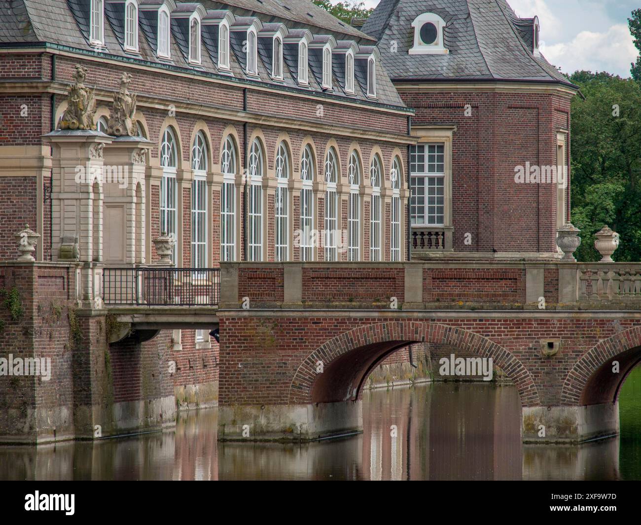 A section of a castle with a classical bridge leading over a moat ...