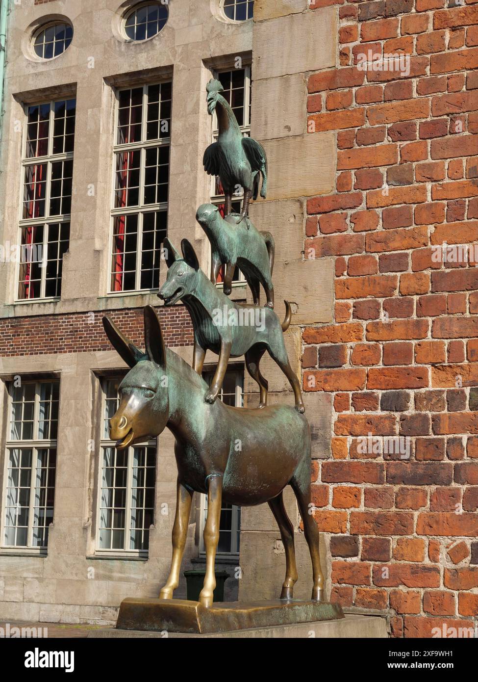Bronze sculpture with stacked animal figures from a fairy tale in front ...