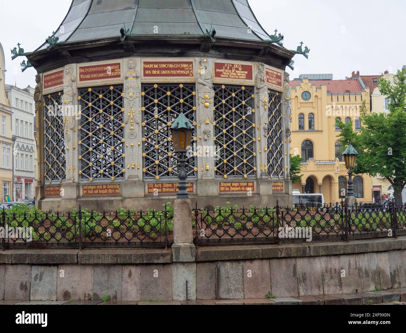 Historic fountain with ornate grating and copper roof, surrounded by ...