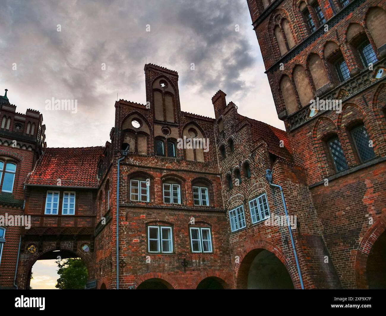 Historic brick buildings and towers in an old town under a cloudy sky ...