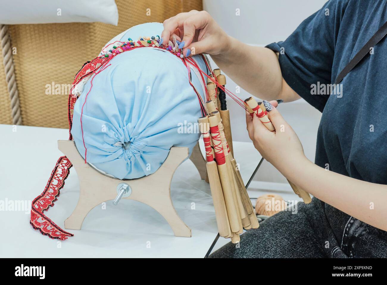 Girl's hands spin braid on bobbins. Special lace weaving technique ...
