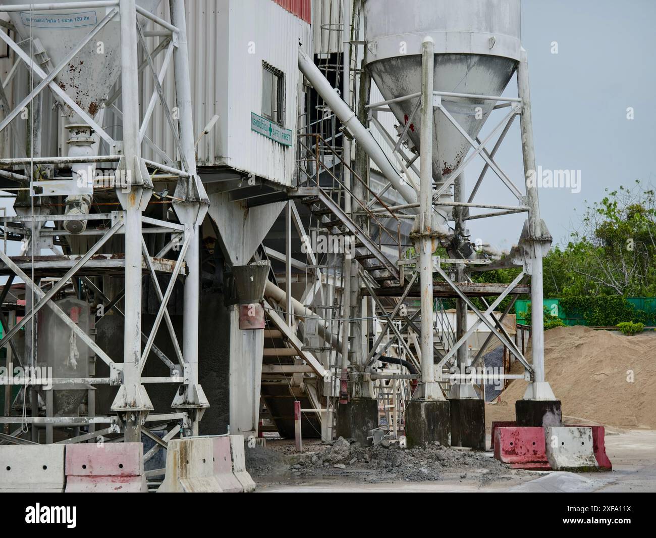 A stationary with pipes outside of a concrete factory Stock Photo - Alamy