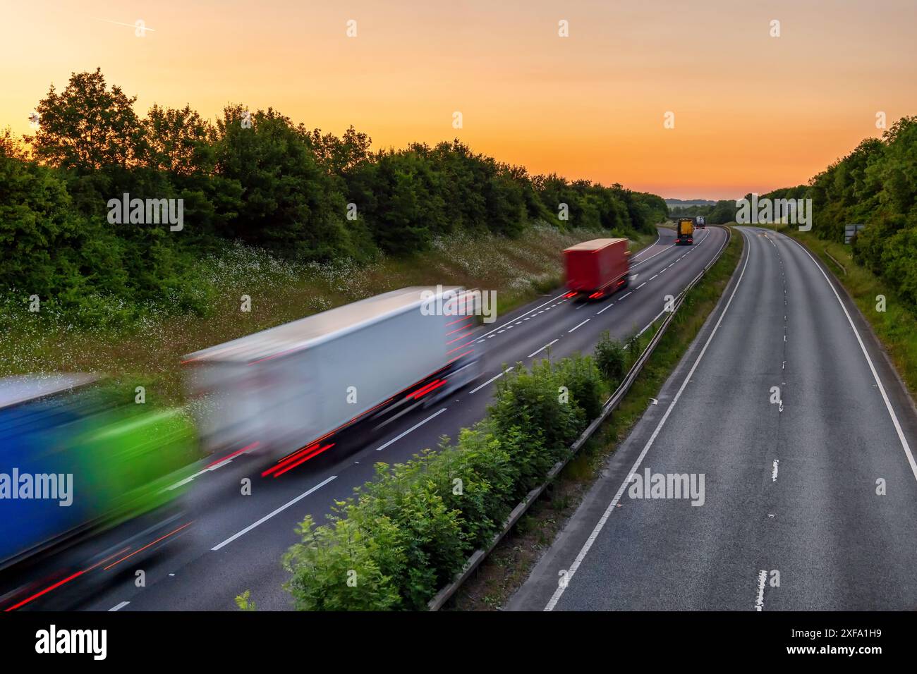 heavy traffic moving at speed on UK motorway in England at sunset Stock ...