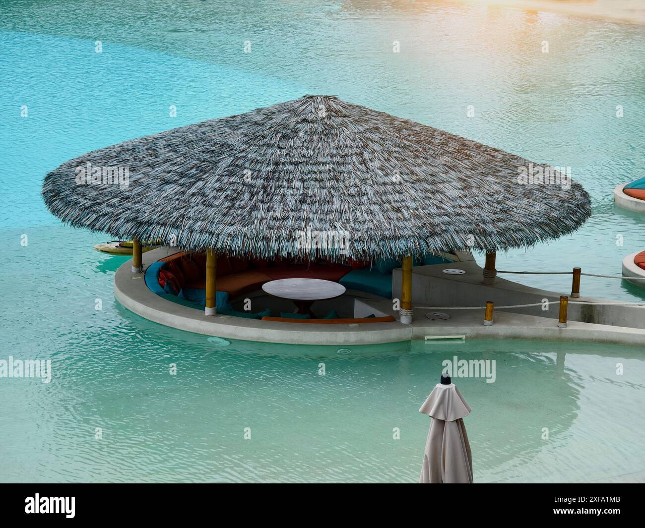 A traditional thatched hut is located within a swimming pool Stock ...
