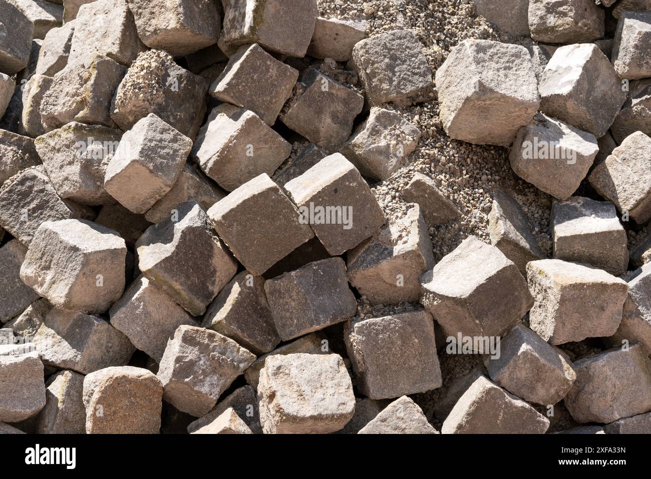Texture of pile of cubic paving stones, arranged irregularly. The ...