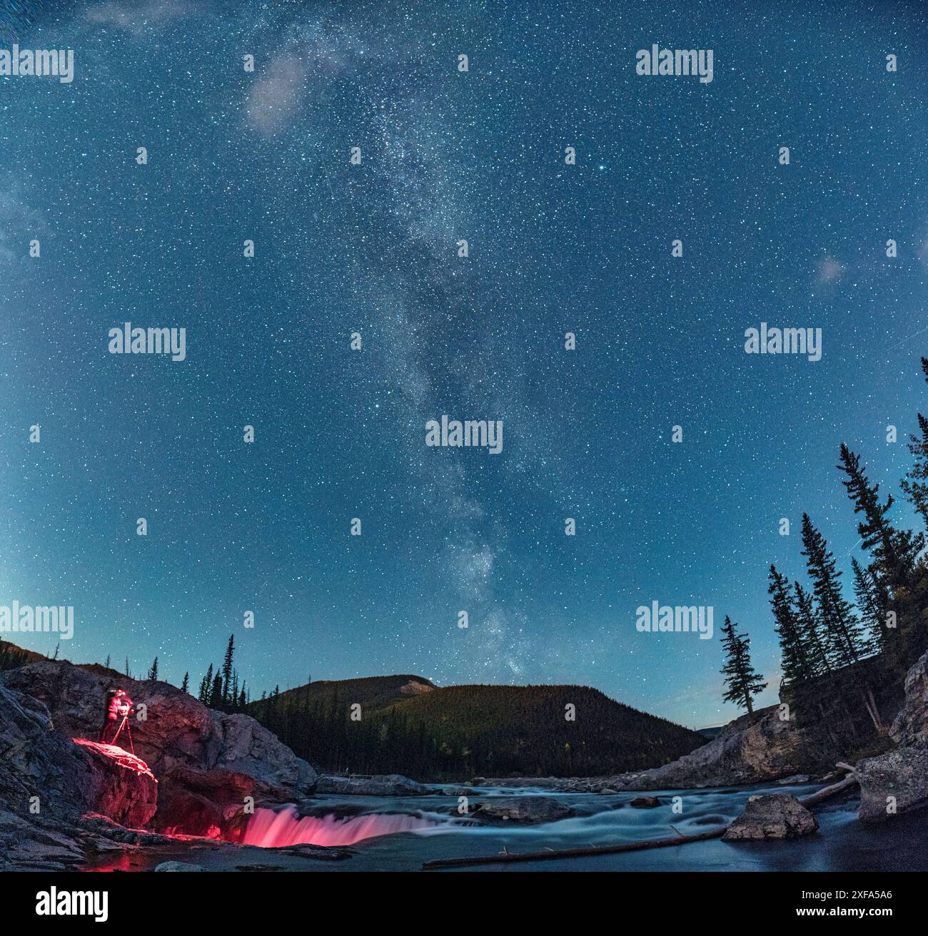Landscape of Elbow Falls with milky way and photographer taking photo in the night at Kananaskis ...