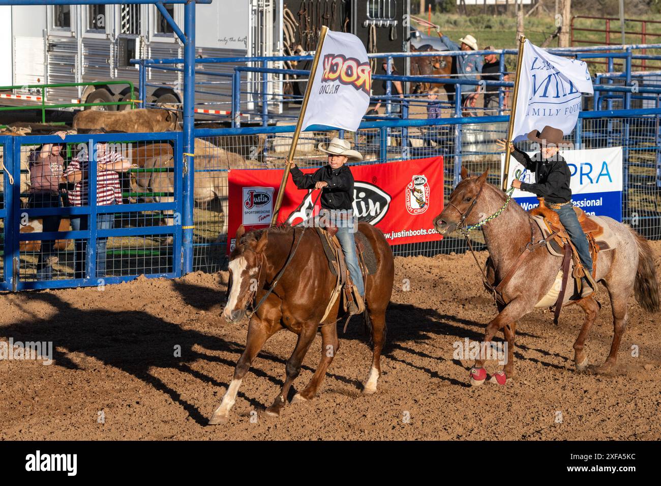 A young cowgirl & cowboy carry the sponsors flags in the Grand Entry at ...