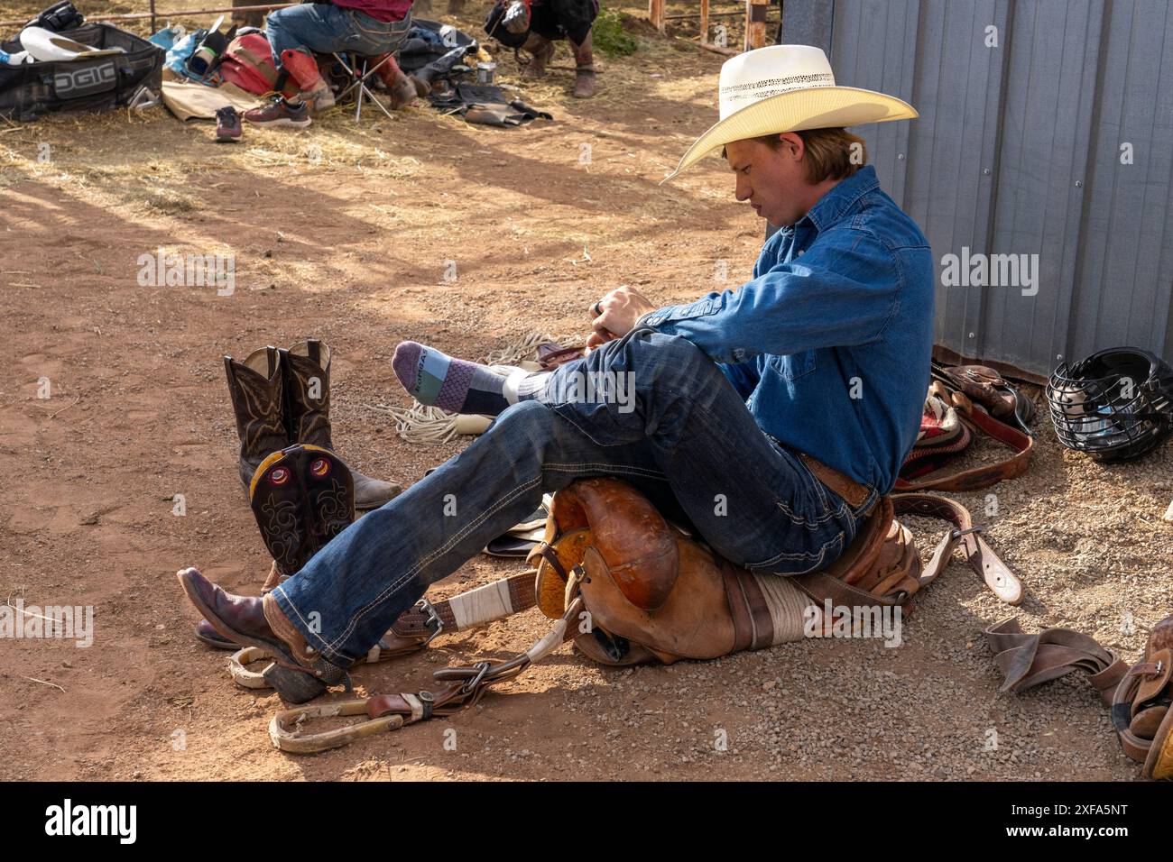 Saddle bronc cowboy Garret Uptain sits on his bucking saddle and gets ...