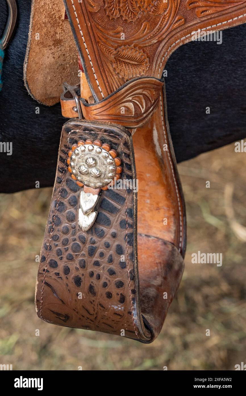 Detail of engraved silver trim on a tooled leather stirrup on a rodeo specialty act performing ...