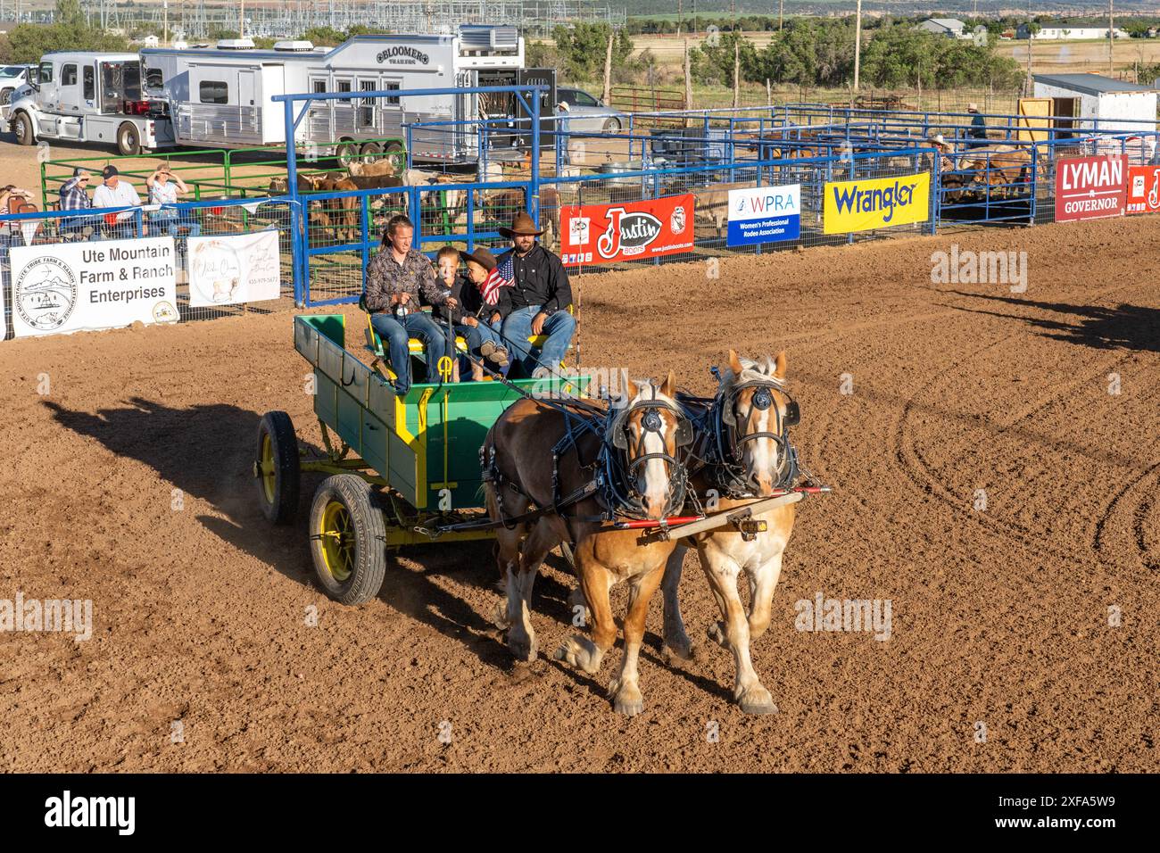 A ranching family in a wagon pulled by draft horses in the Grand Entry ...