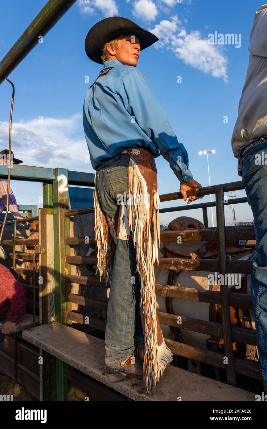 Saddle bronc cowboy Josh Davison in his fringed leather chaps stands at ...