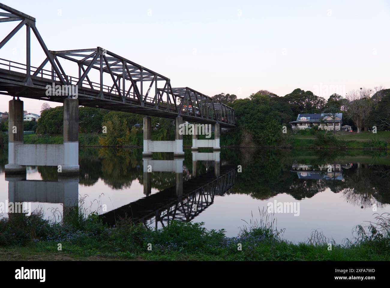 The image captures a serene sunset scene over the Macleay River in ...