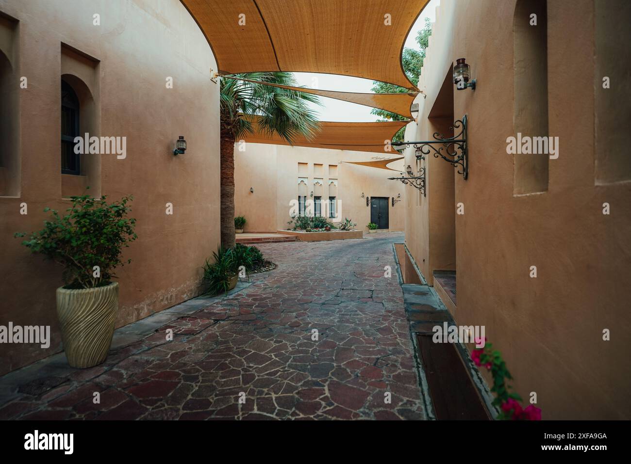 A picturesque alley with traditional architecture and shade sails in a ...