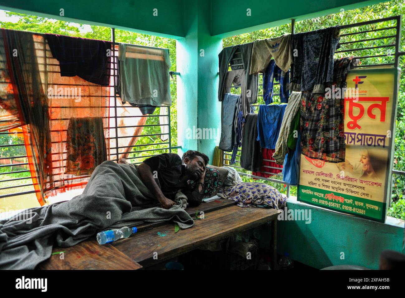 Flood-affected people take temporary shelter at a school in Dhigli area of Sylhet-Sunamgonj Road ...