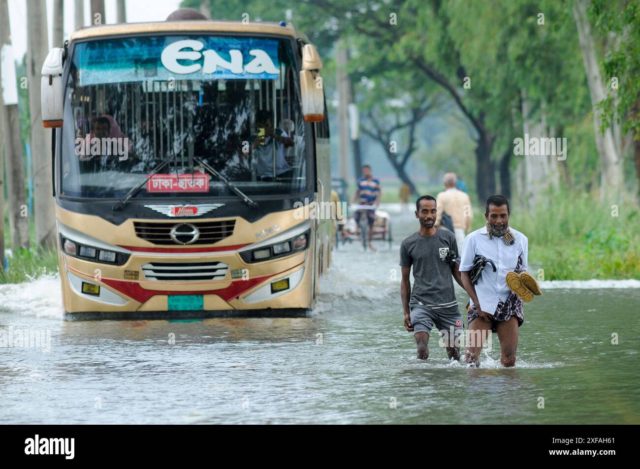 People walk through floodwaters in Gobindogonj - Chhatak road of ...