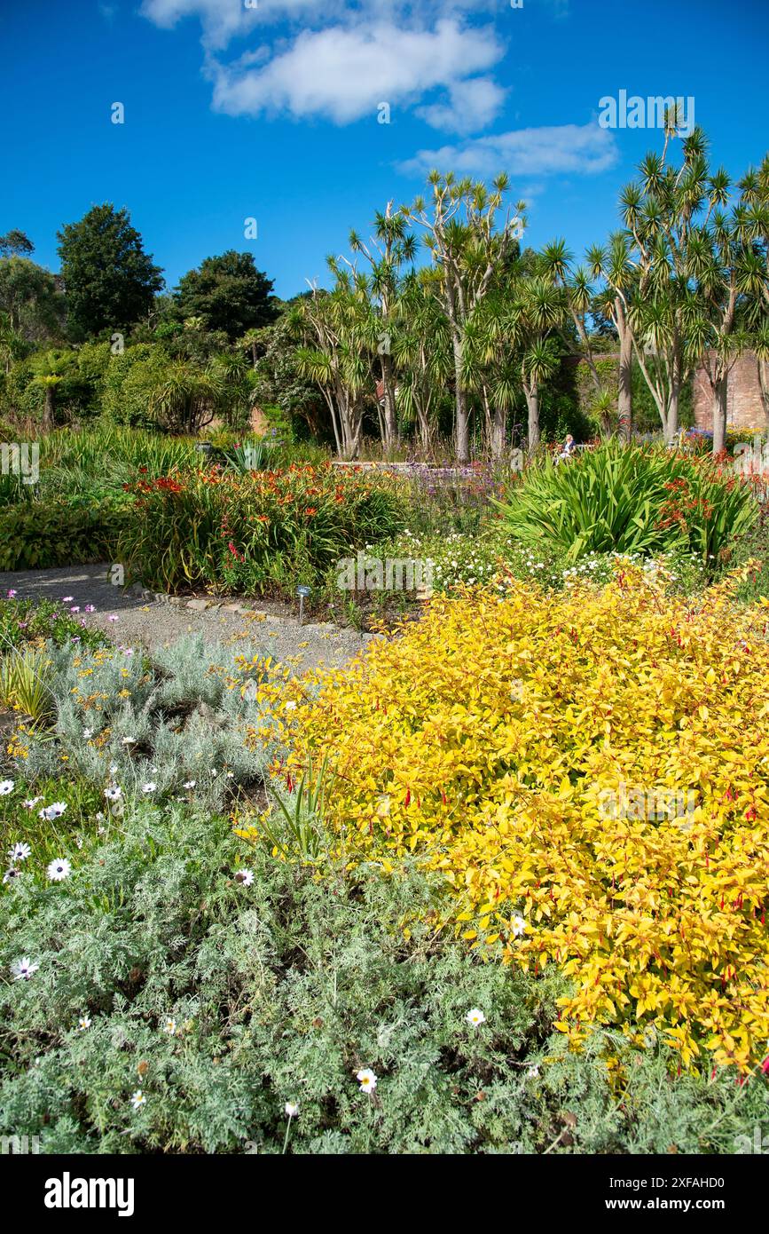 late summer colours and a woman sat on a bench enjoying the sunshine at ...