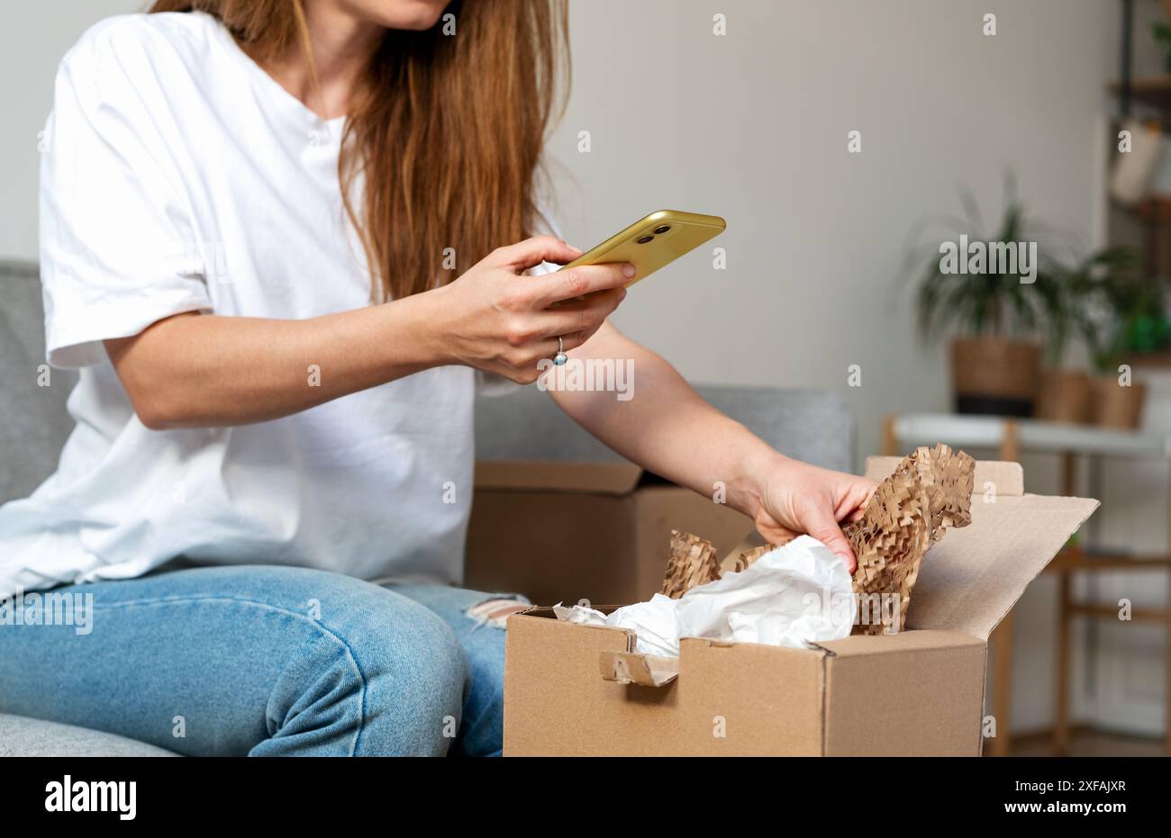 Female unpacking parcel at home and photographing online order. Sharing ...