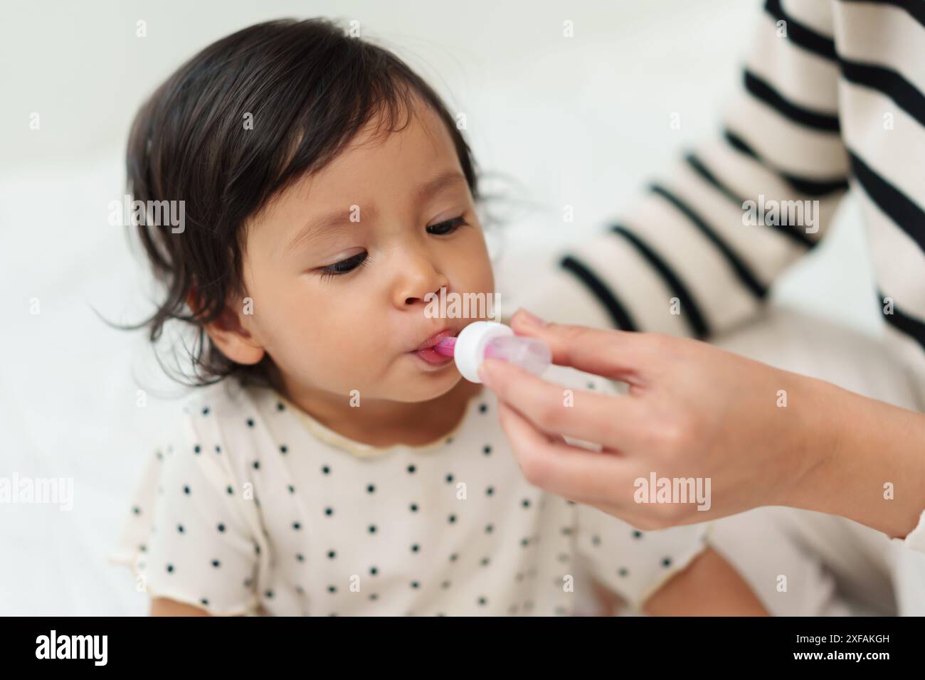 mother feeding a liquid medicine to sick toddler girl with dropper ...