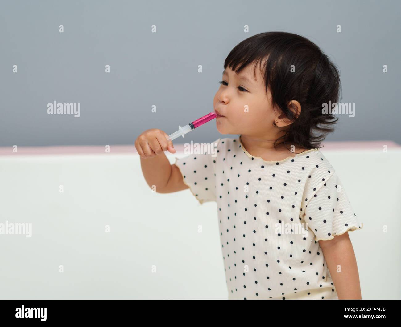 baby girl takes syrup medicine with syringe by herself. sick toddler ...