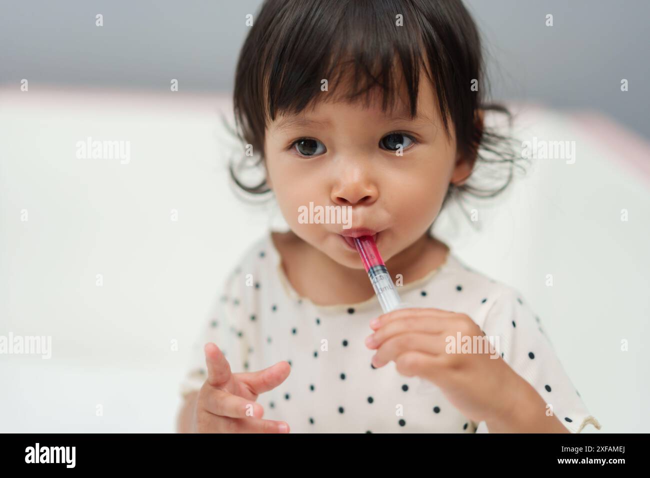 baby girl takes syrup medicine with syringe by herself. sick toddler ...