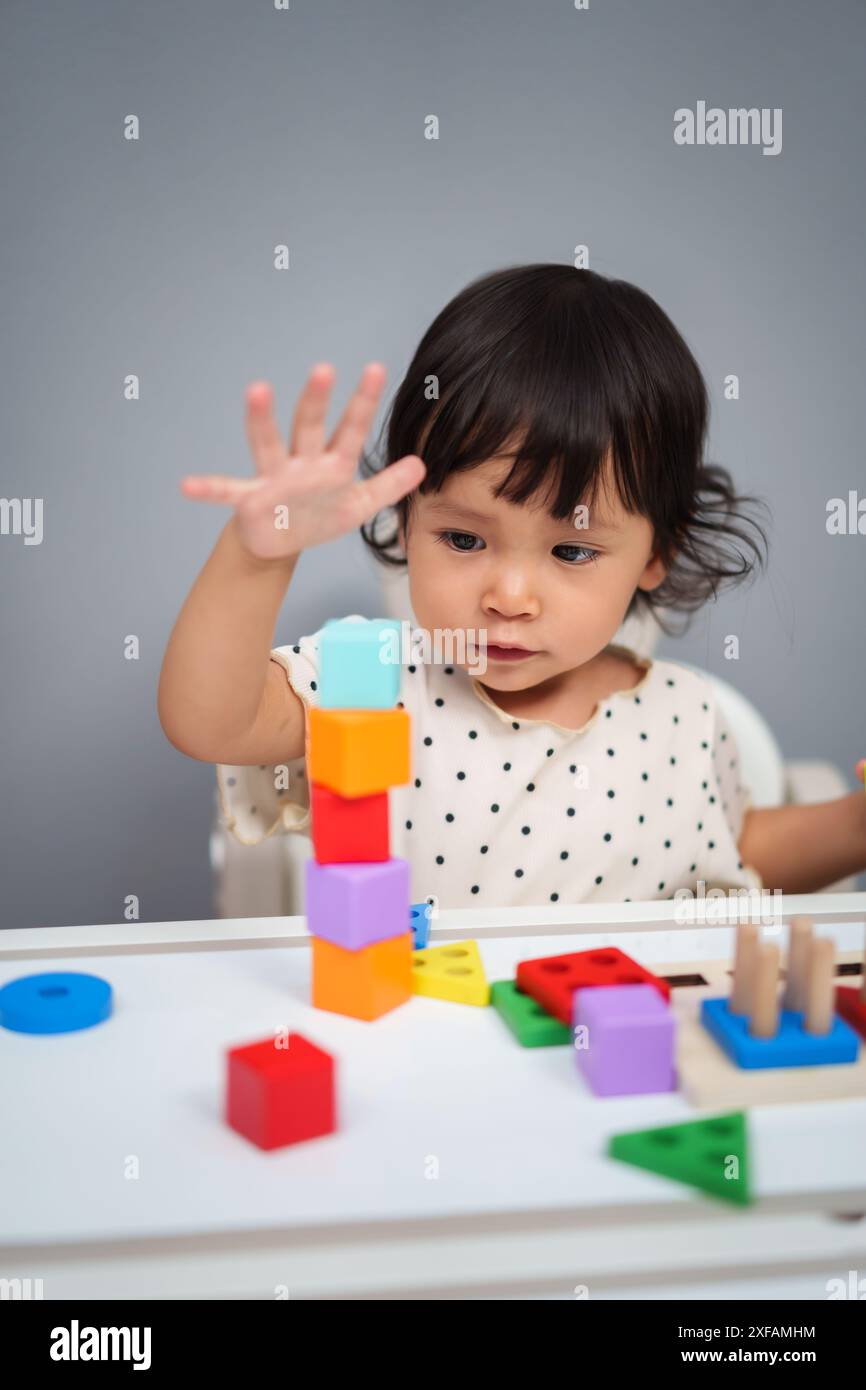 toddler baby playing block toy to stacks building cubes on the table ...