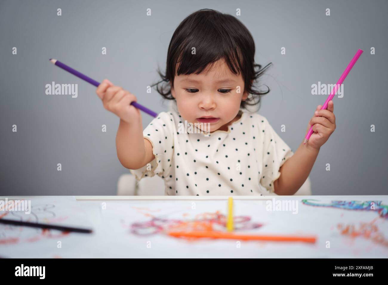 toddler baby playing and training to drawing with colored pencil on the ...