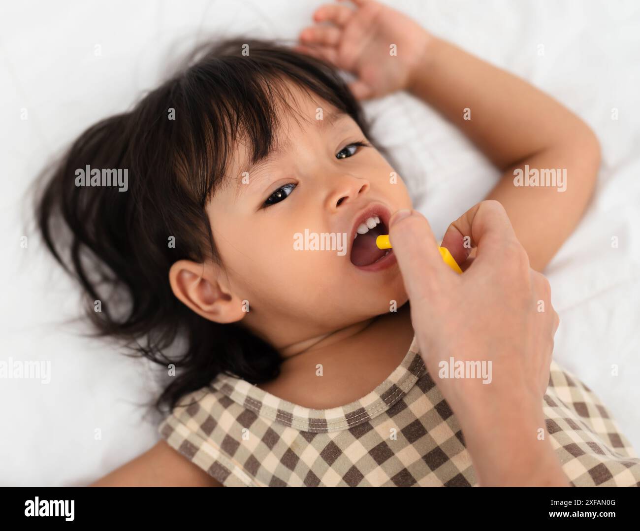 Mother Or Doctor Spraying Medicine In Mouth Of Toddler Girl Baby Sore mother-or-doctor-spraying-medicine-in-mouth-of-toddler-girl-baby-sore
