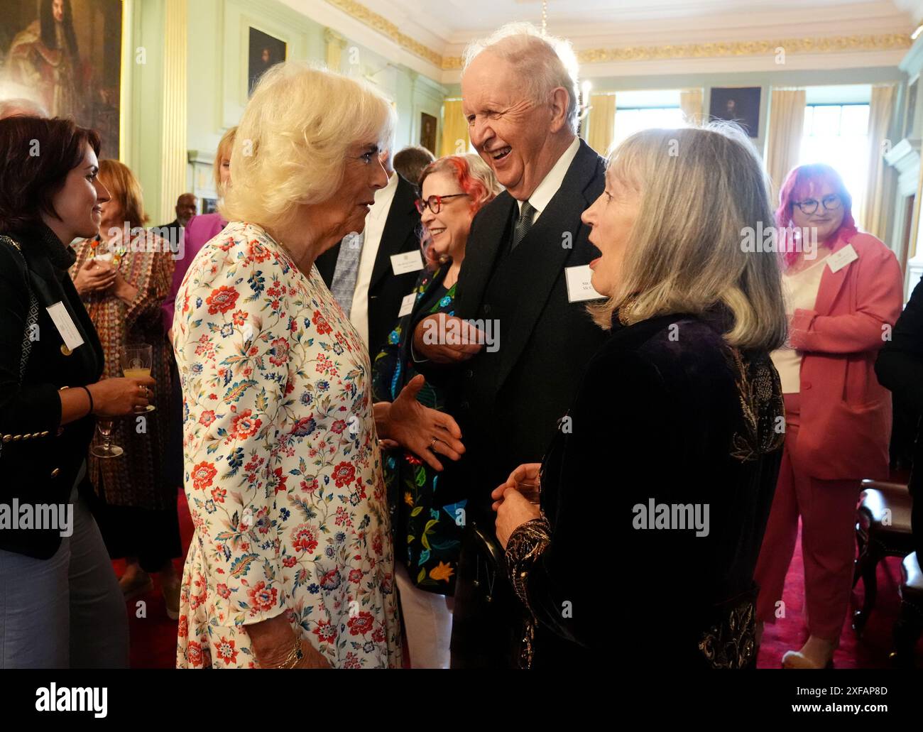 Queen Camilla (left) speaks to Sir Alexander McCall Smith (centre) and ...