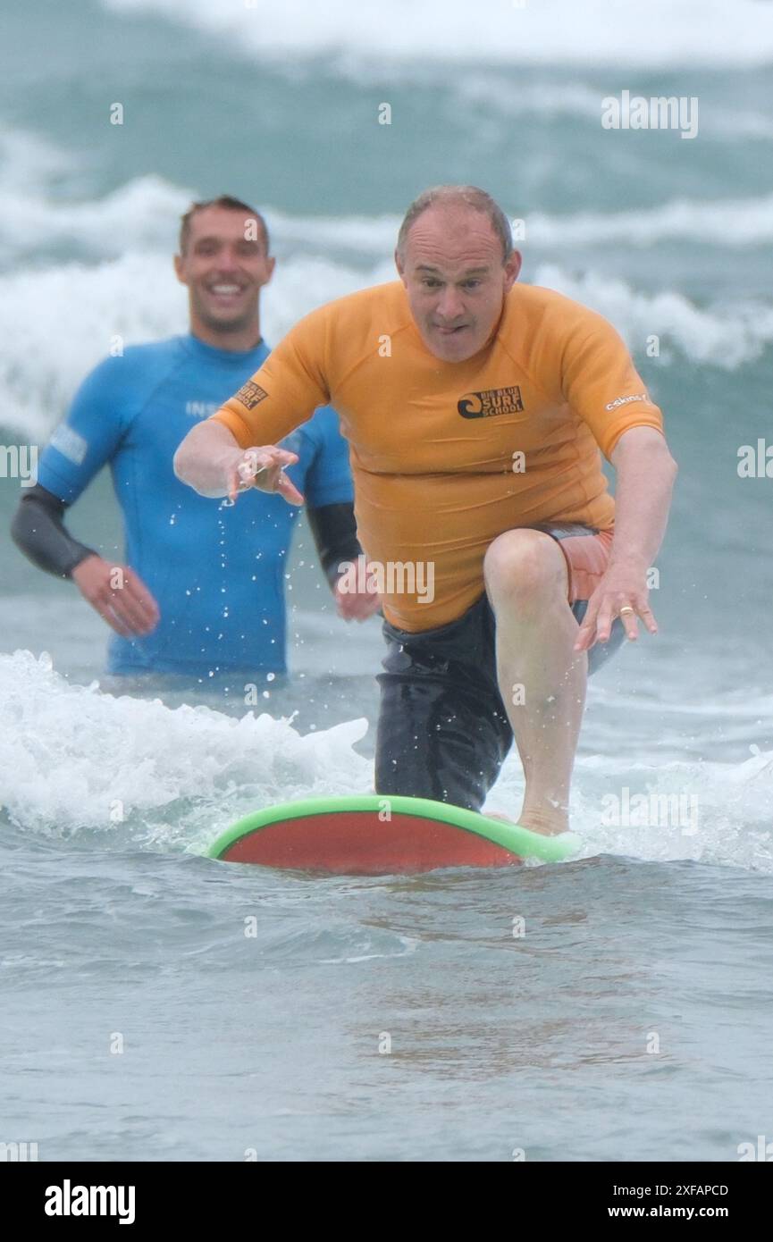 Liberal Democrat leader Sir Ed Davey on a surfboard during a visit to ...