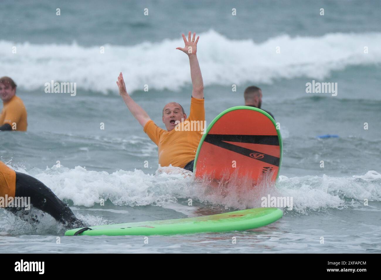 Liberal Democrat leader Sir Ed Davey falls from a surfboard during a ...
