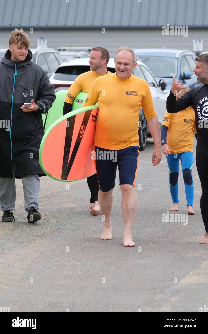 Liberal Democrat leader Sir Ed Davey carries a surfboard during a visit ...