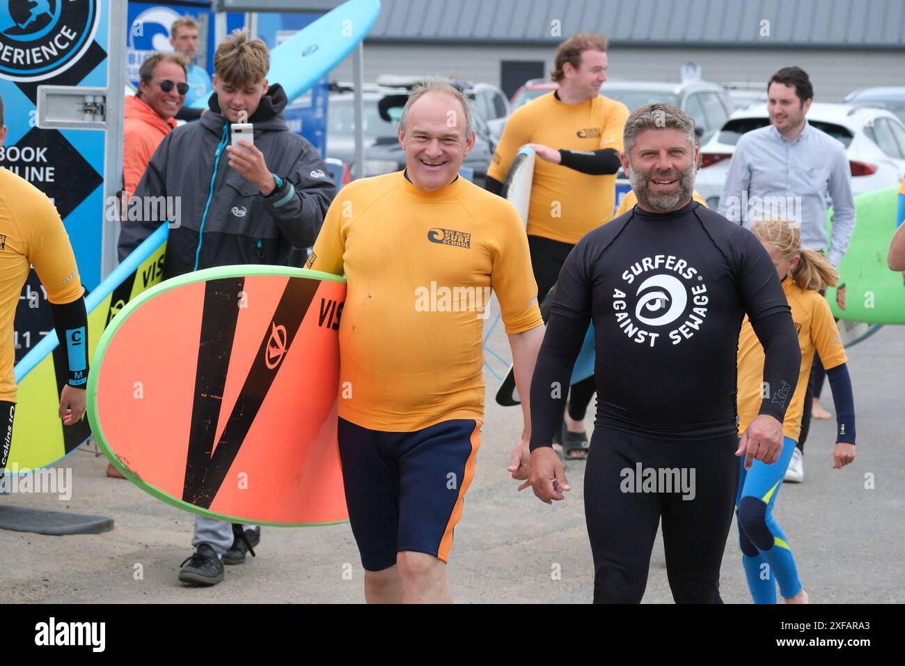 Liberal Democrat leader Sir Ed Davey carries a surfboard during a visit ...