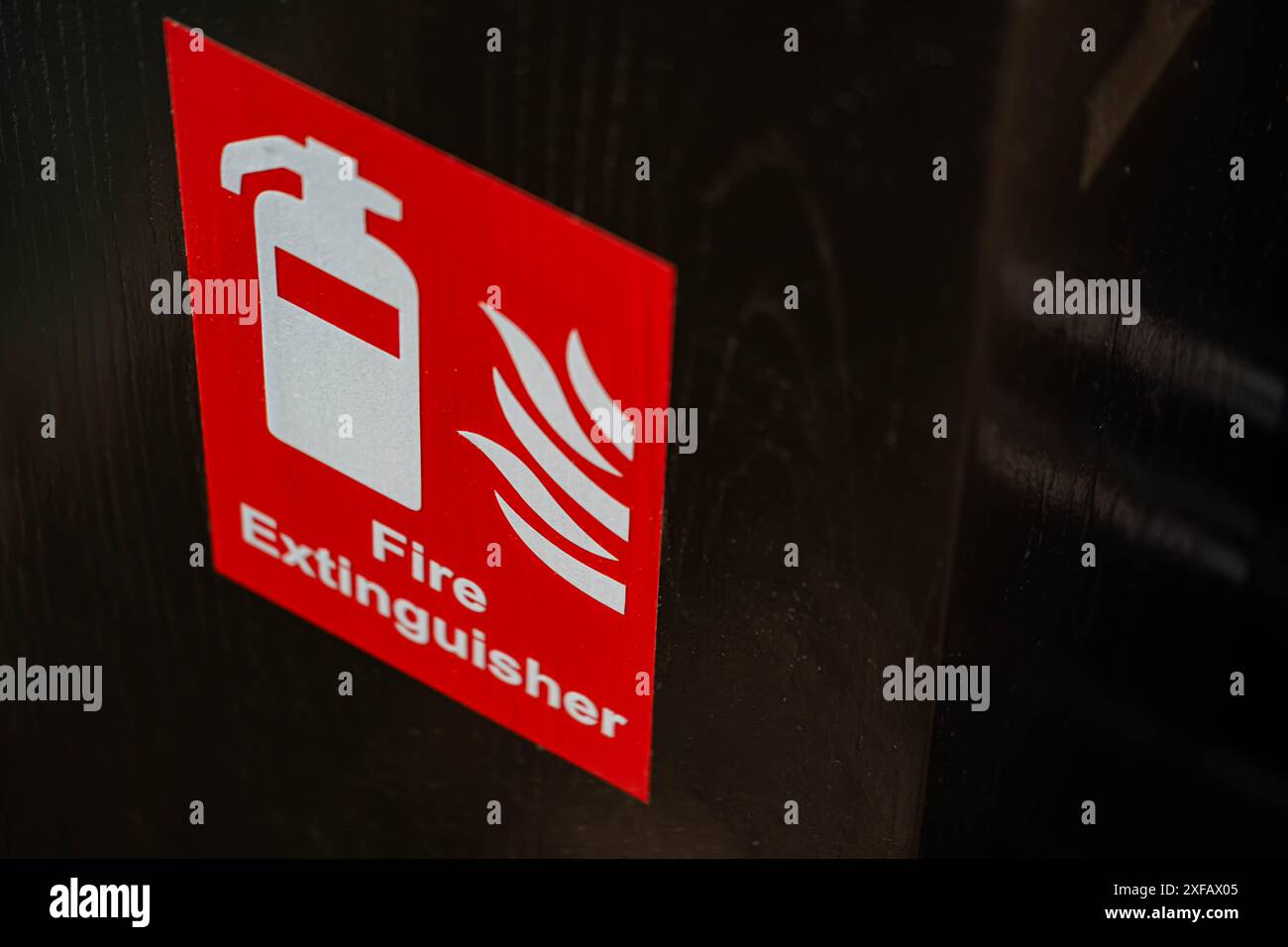 A close-up of a red fire extinguisher sign with white text and symbols ...