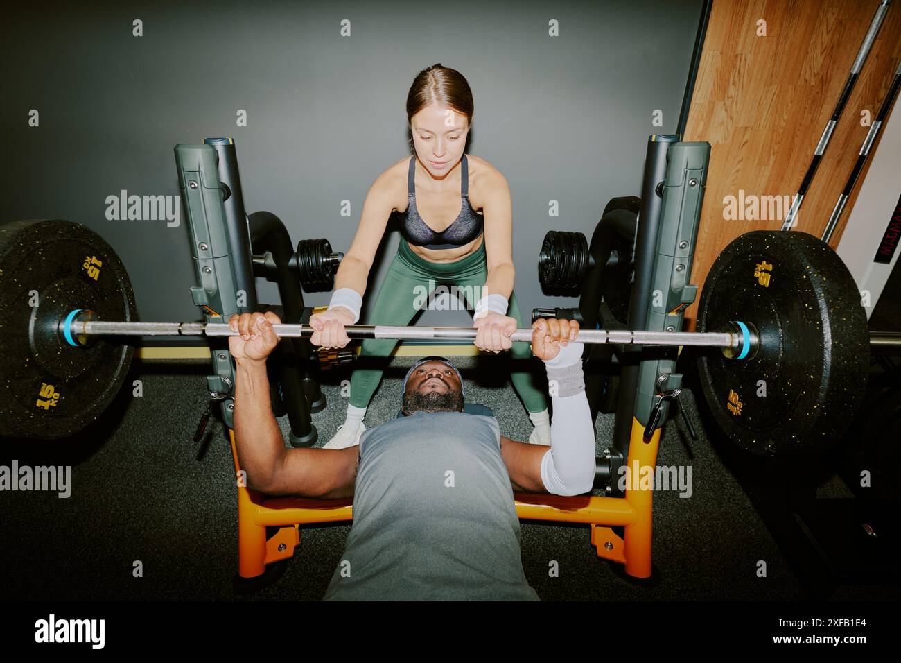 Female athlete helping her shredded African American friend with ...