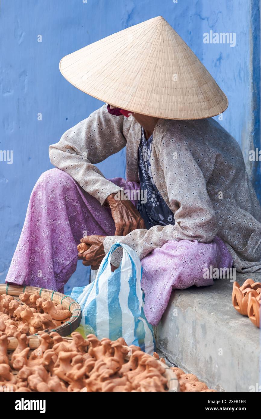 Vietnamese Old woman in traditional conical hat in old city Hoi An ...