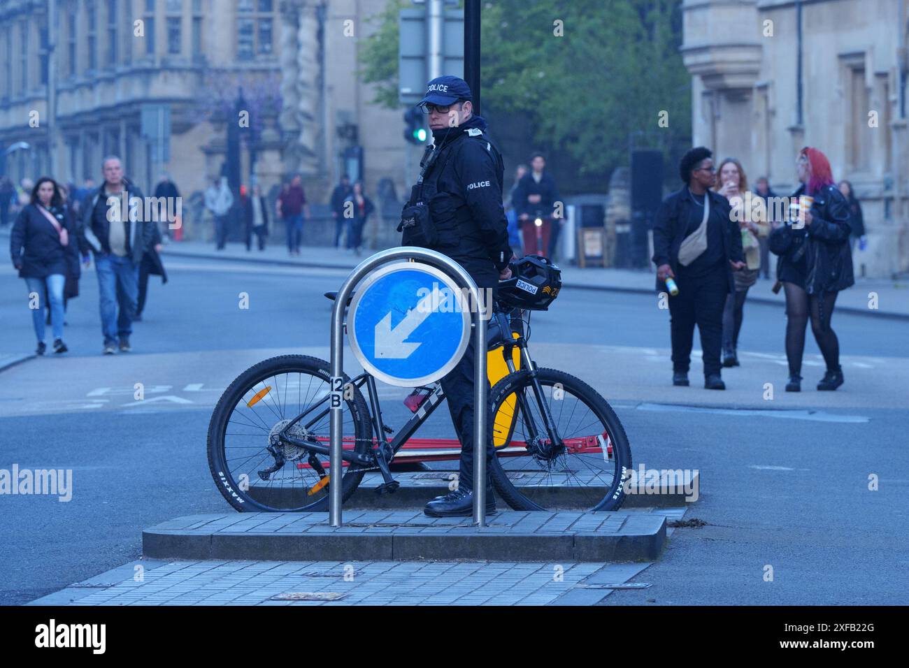 A police officer monitors the streets as members of the public walk ...