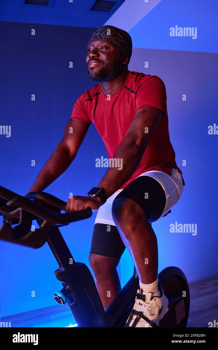 Buff African American man warming up his joints using exercise bike, he ...