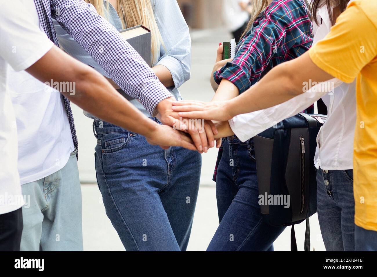 Togetherness, unity concept. Students putting their hands together ...