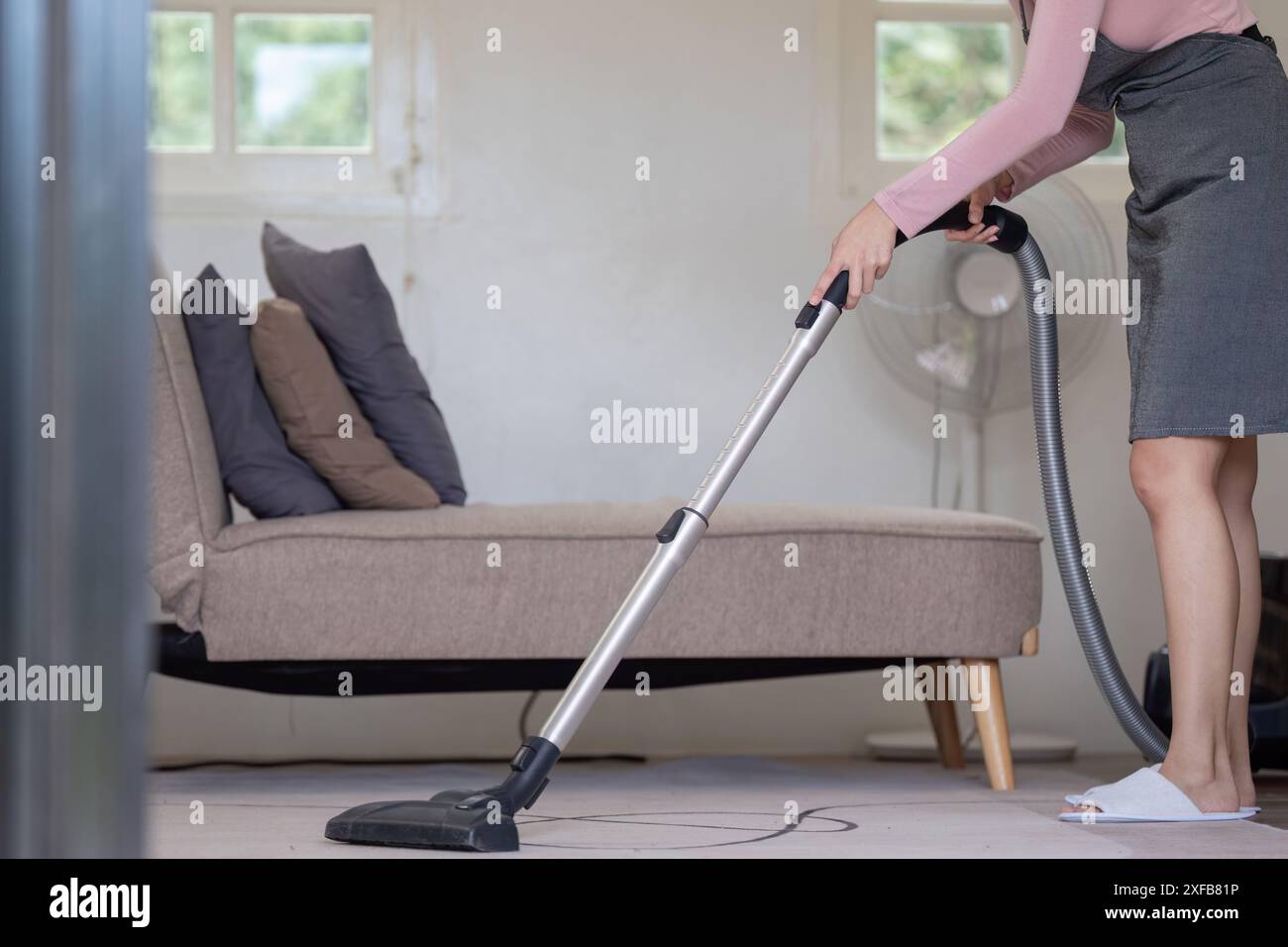 Housekeeper Vacuuming Living Room Floor in Modern Home. Professional ...