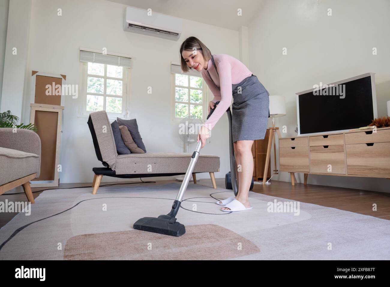 Housekeeper Cleaning Living Room with Vacuum Cleaner in Modern Home ...
