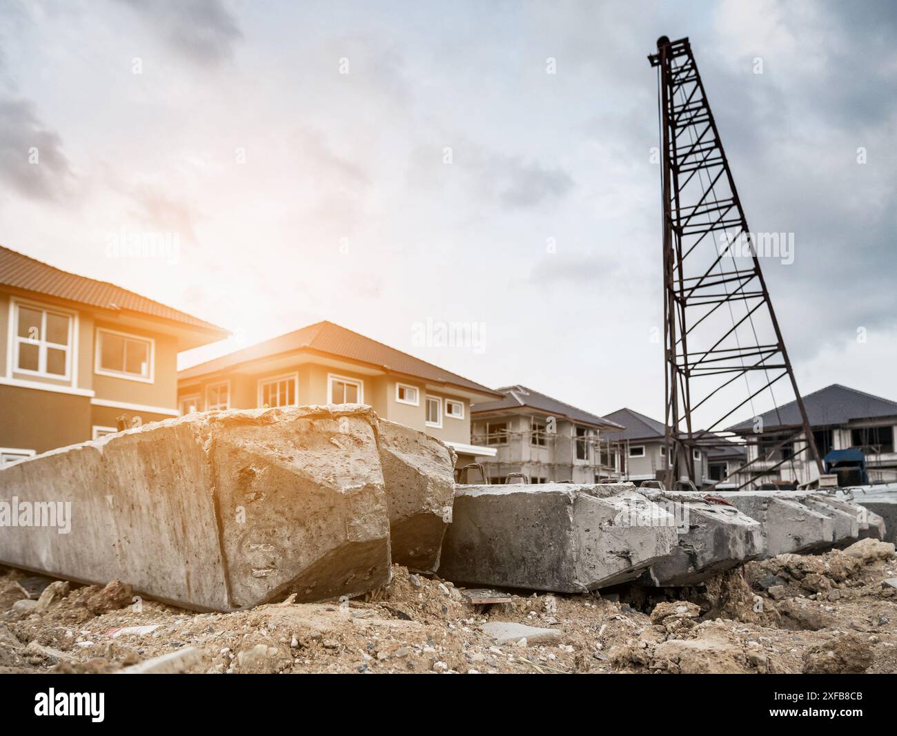 house building at construction site with pile driver and precast ...
