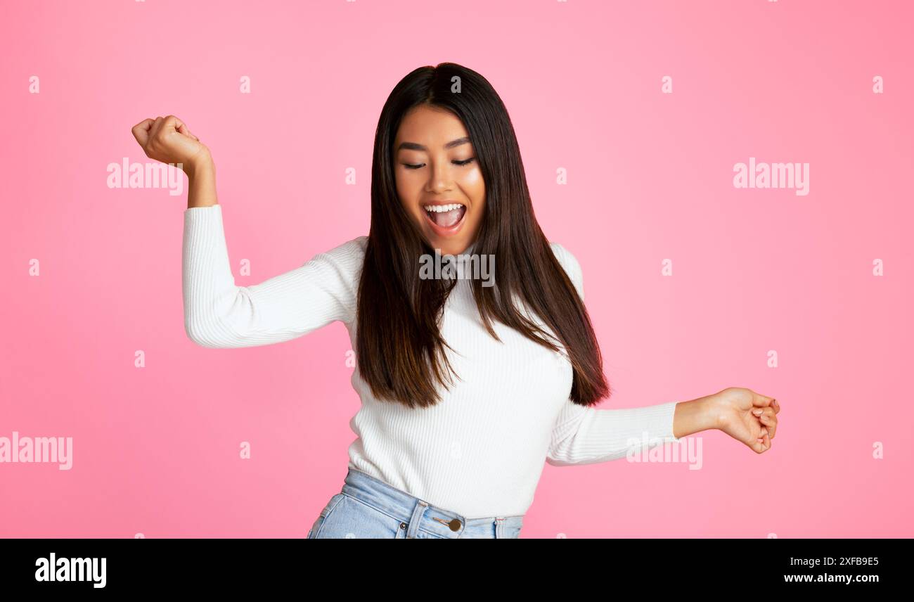 Happy Young Woman Dancing in Front of Pink Background Stock Photo - Alamy